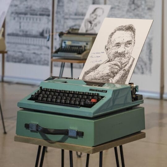 Artist creating drawings using a vintage typewriter machine ...